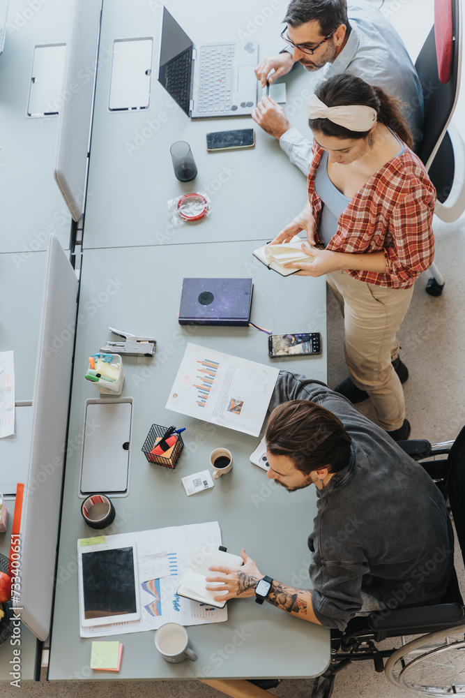 Overhead shot of a professional team hard at work in a bustling office ...