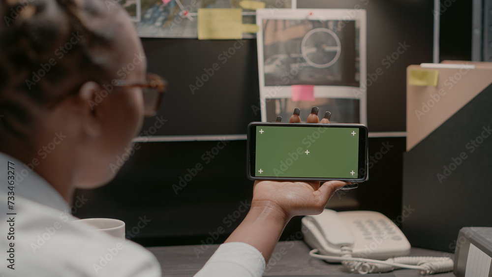 Police officer using greenscreen in evidence room, showing mockup ...