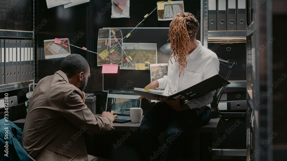 Two police officers looking at detective evidence map, investigators ...