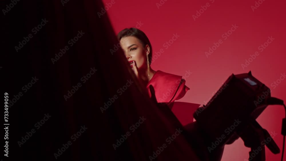 Model in elegant red dress posing for a smartphone photo shoot. Fashion ...