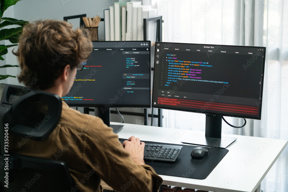 IT developer working online software development on pc monitors at modern home office on coding ...