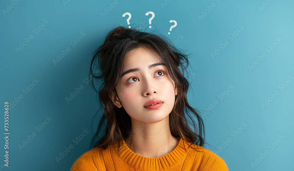 Young asian woman expressing doubt on her face, with question symbols ...