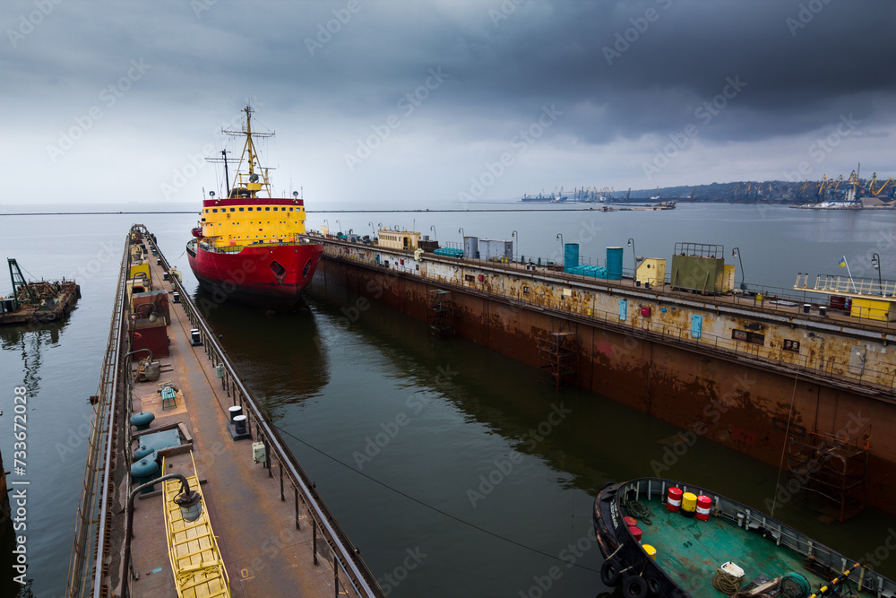 Red icebreaker docked in shipyard floating dry dock for repair, under ...