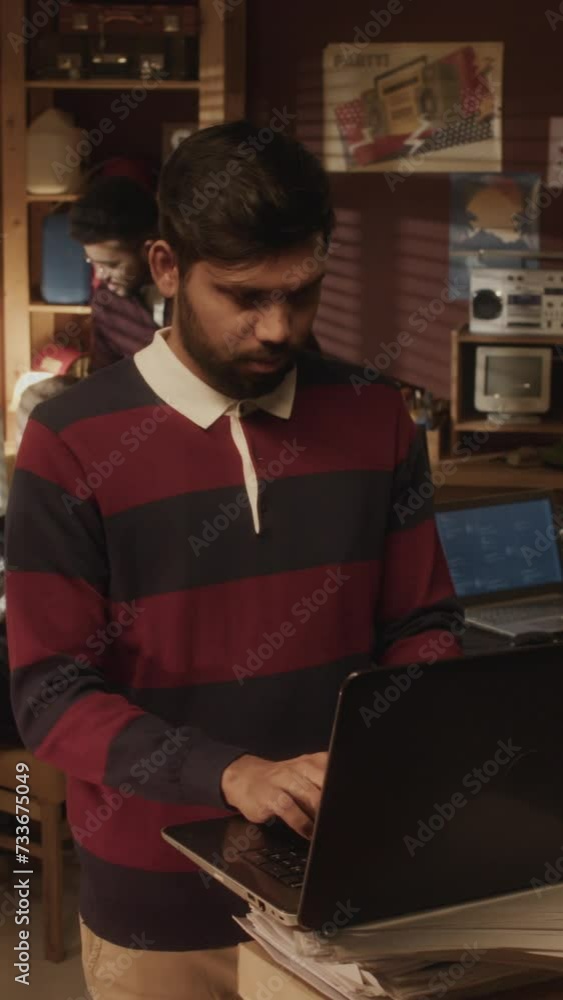 Vertical medium shot of young Biracial male programmer wearing striped ... Vertical medium shot of young Biracial male programmer wearing striped ...