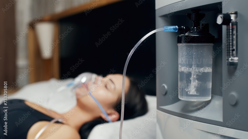 Portrait of a sick young woman who uses an oxygen concentrator and an ...