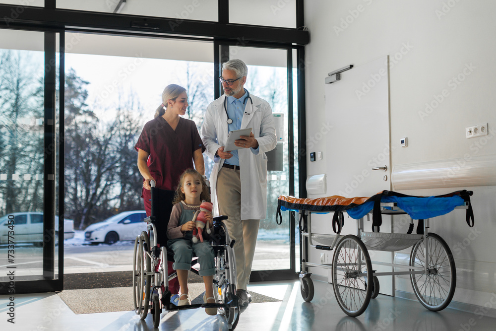 Friendly pediatrician nurse talking, pushing little patient in ...