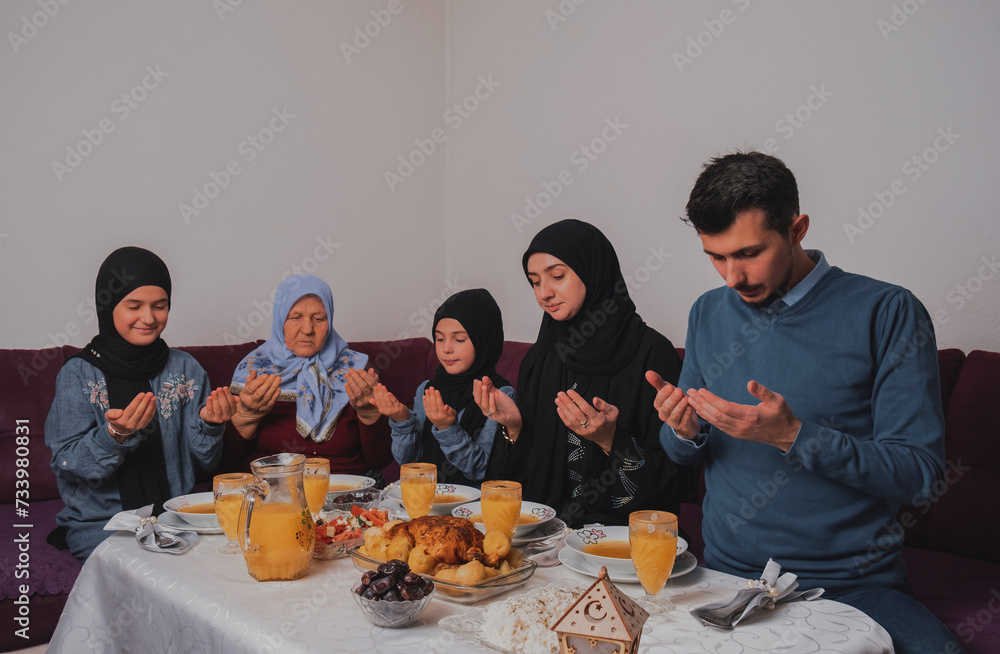 Muslim family making iftar dua to break fasting during Ramadan happy ...