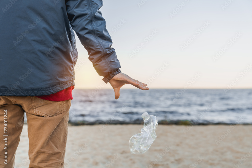 Ecology concept. Man throwing plastic bottle on the beach. Littering ...