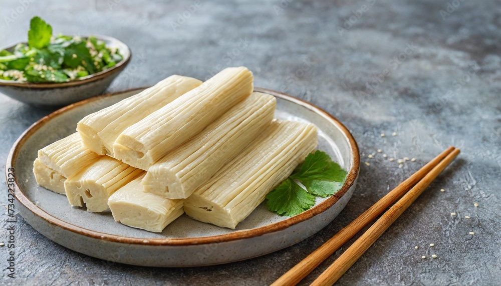 tofu skin yuba sticks or fuzhu and chopsticks on a concrete table ...