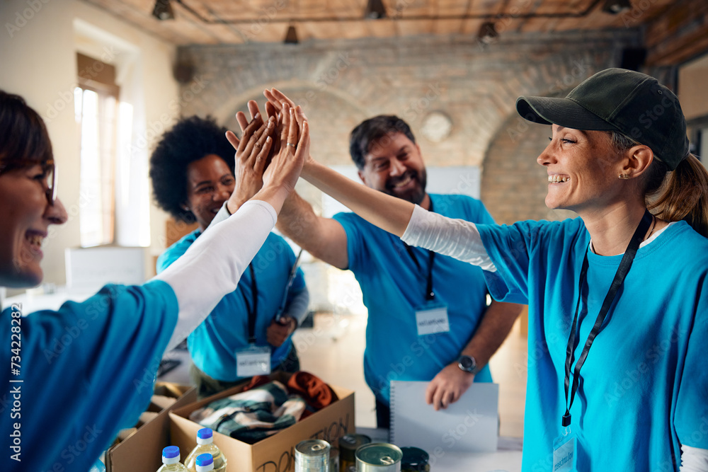 United team of volunteers gathering their hands while working at ...