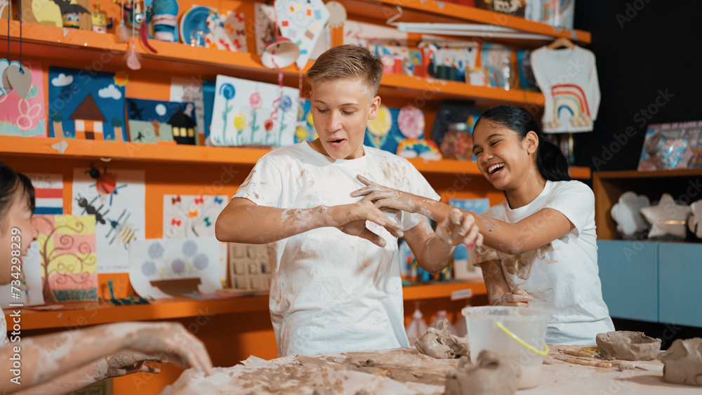Diversity happy student playing clay while put on shirt at art lesson ...