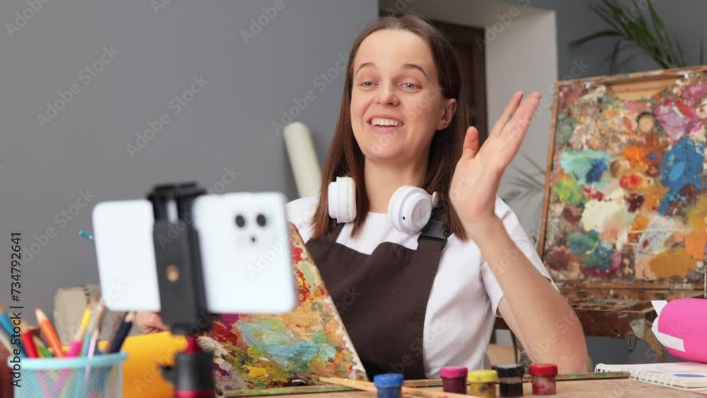 Joyful Caucasian brown haired woman recording master class of drawing ...