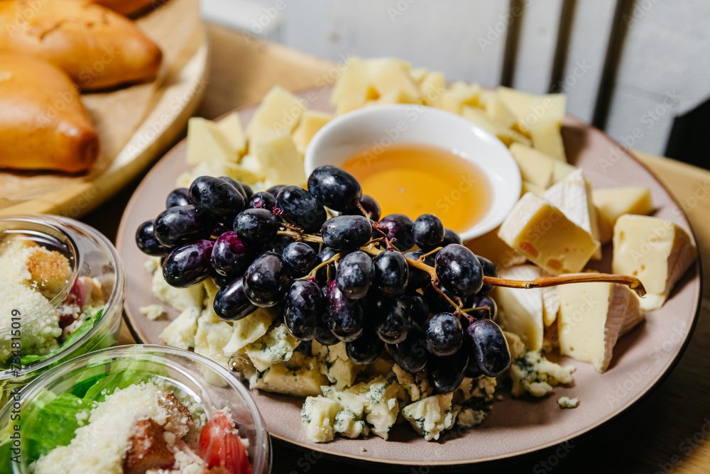 Cheese Platter with Grapes and Honey Dip. A variety of gourmet cheeses ...