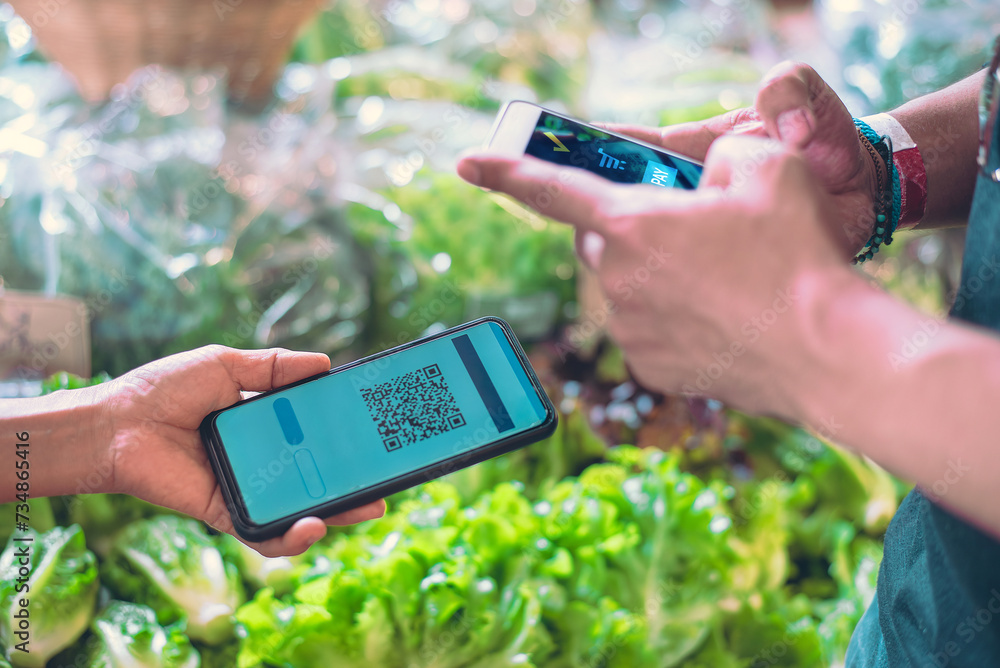 Two people perform a mobile transaction using QR code amidst fresh ...