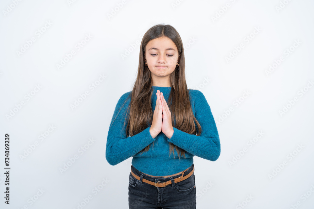 Young beautiful teen girl wearing blue T-shirt begging and praying with ...
