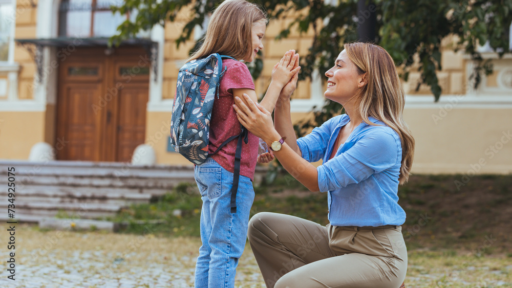 Mother taking her daughter to school. Mother preparing her child for ...