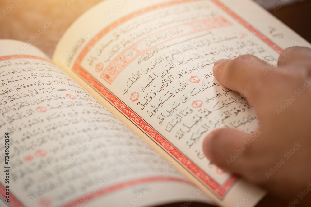 Quran (Koran) - close up of holy book of Muslims, with hand pointing ...