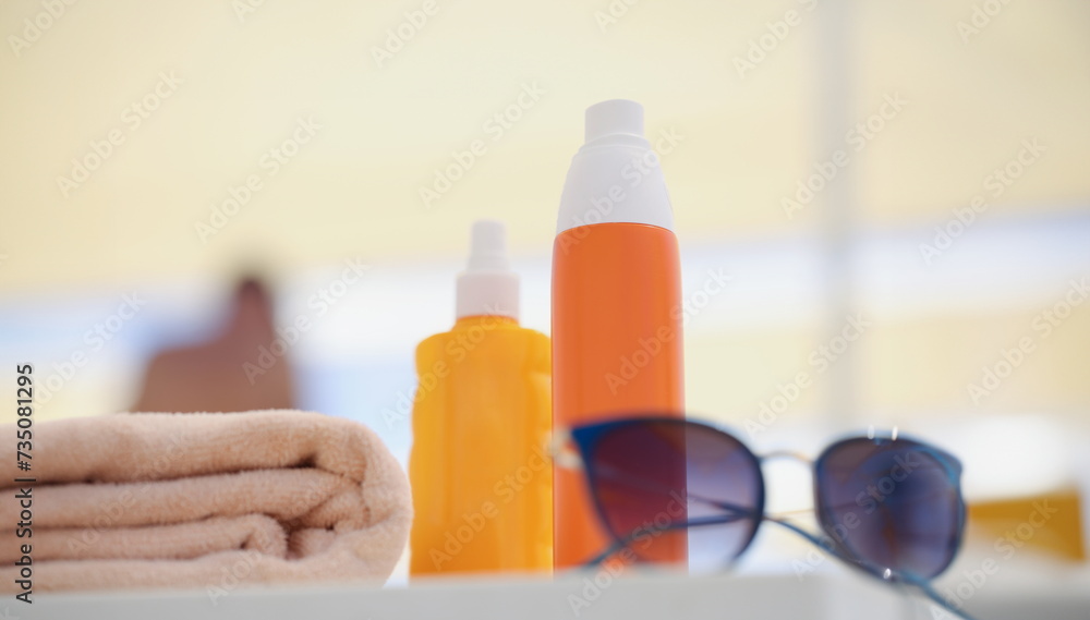 Orange and yellow bottles with a dispenser, close-up, blurry. Sun ...