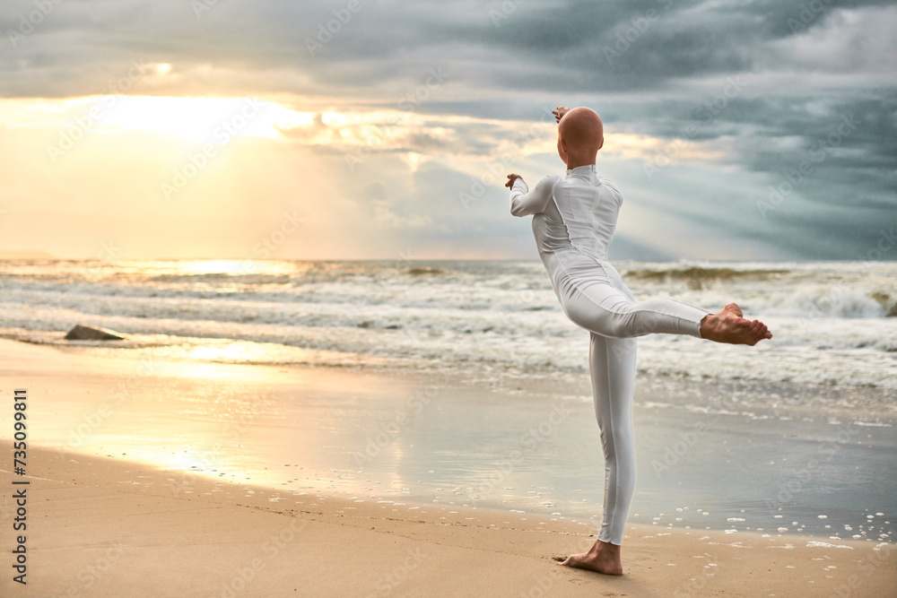 Young hairless ballerina with alopecia in white futuristic suit dancing ...