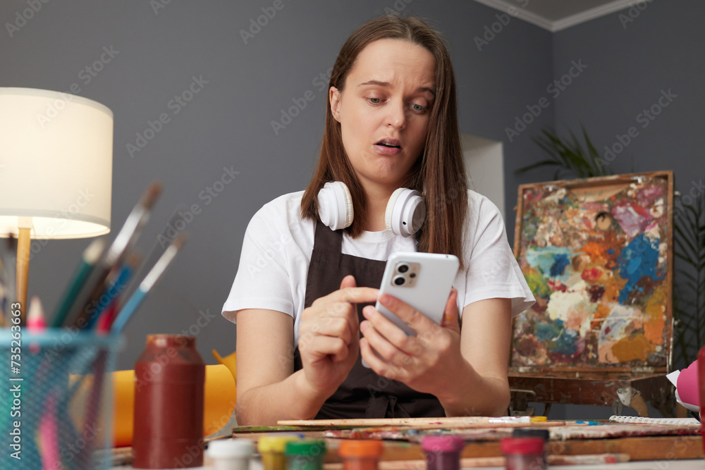 Shocked surprised brown haired woman artist drawing with paints and ...