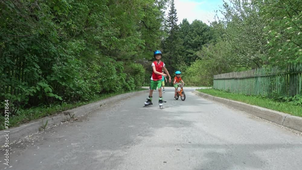 Kids biking and rollerblading. Boy riding on roller skates at outdoor ...
