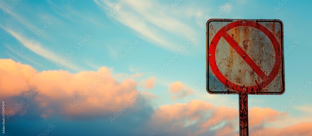 Weathered and rusted no entry sign hanging on a post against a clear ...