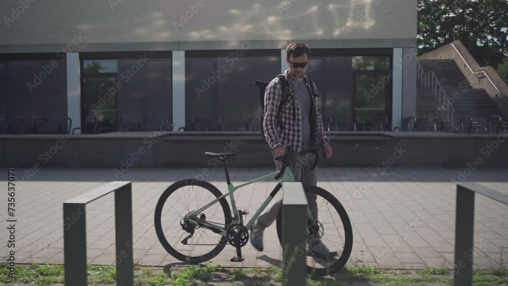 Cyclist parks and locks bicycle in public bike parking lot in Germany ...