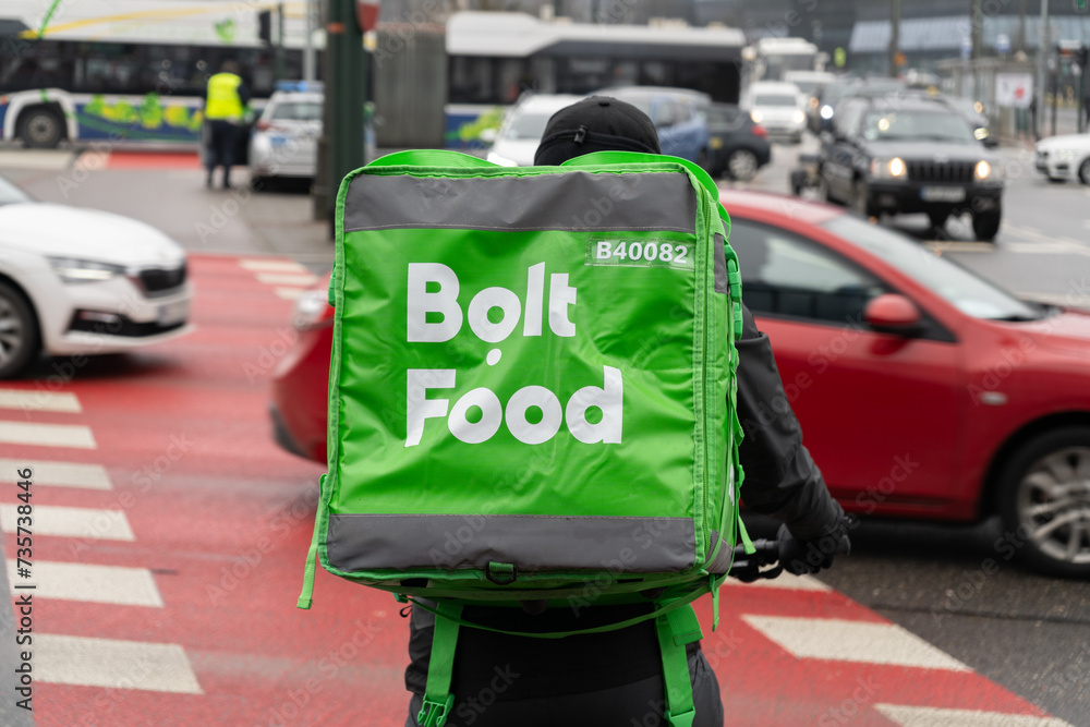 Bolt Food bike courier, with logo sign on a backpack. Take away food ...