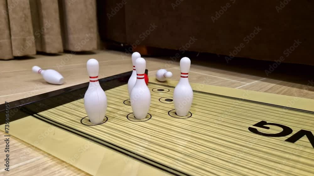 In toy bowling alley, ball strikes the pins, causing them to tumble See ...