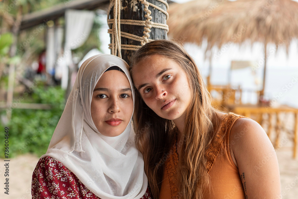 Foto de Portrait of two female best friends, one is wearing a hijab in ...