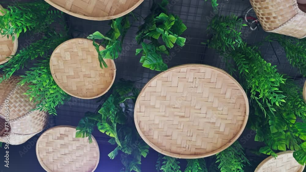 Vidéo Stock Woven bamboo baskets on a wall with green ferns creating a ...
