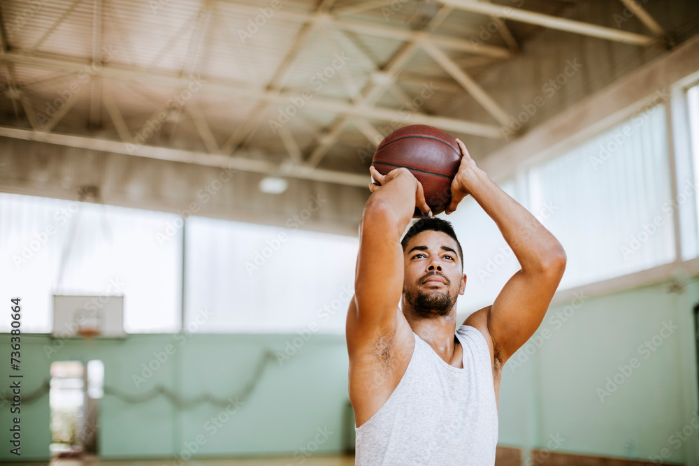Man shooting basketball in indoor gym Stock Photo | Adobe Stock