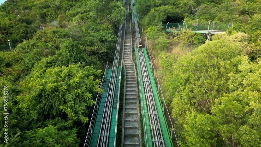 People go up the mountain on an green electric sled. Roller coaster ...