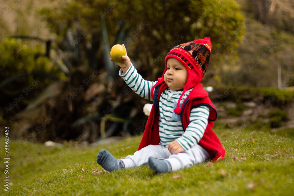 Un bebé sonriente con su chullo tejido, disfrutando del sabor de la ...