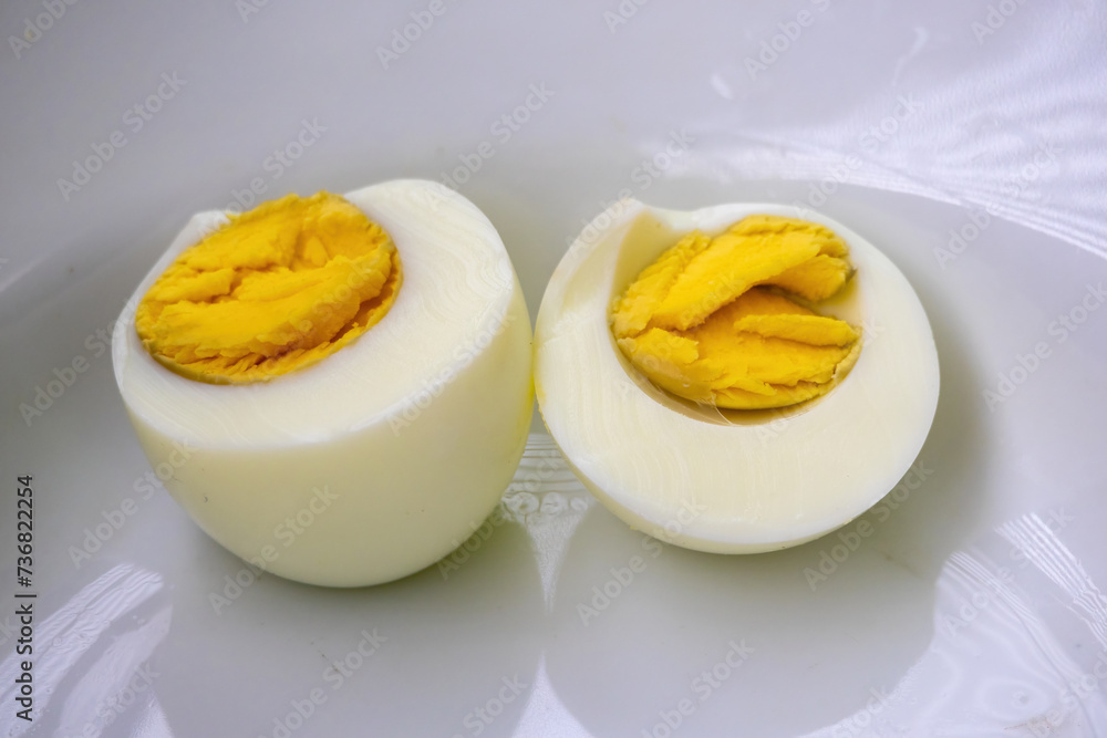 A hard-boiled egg is cut into two pieces. The egg is divided into two ...