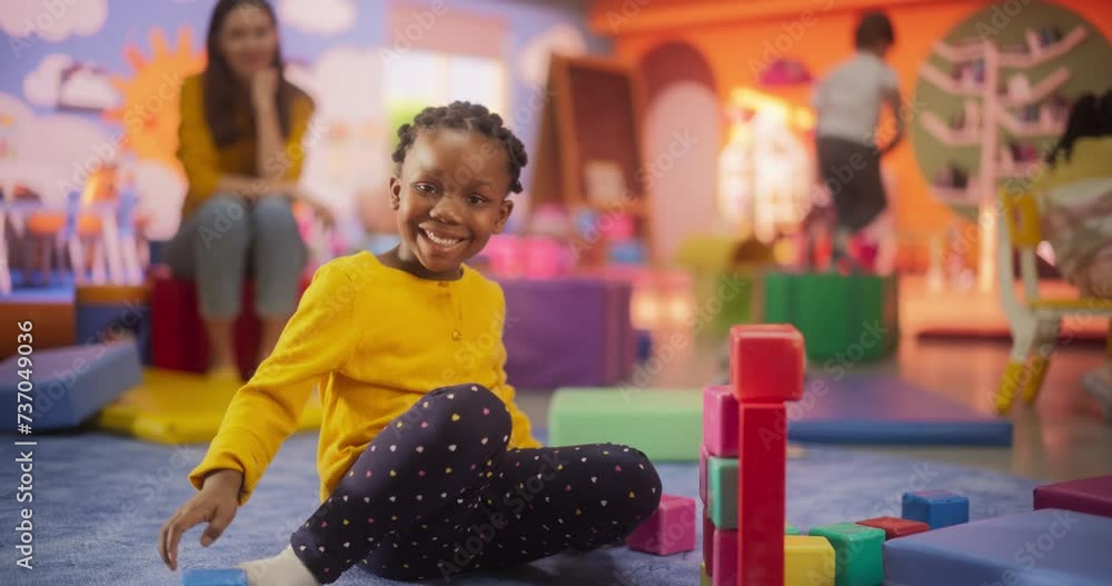 Cheerful African Girl Playing with Colorful Building Blocks in ...