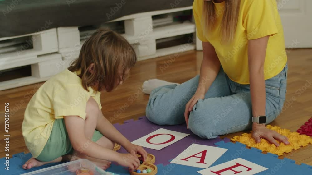 Vidéo Stock Child and therapist practicing letter recognition with ...