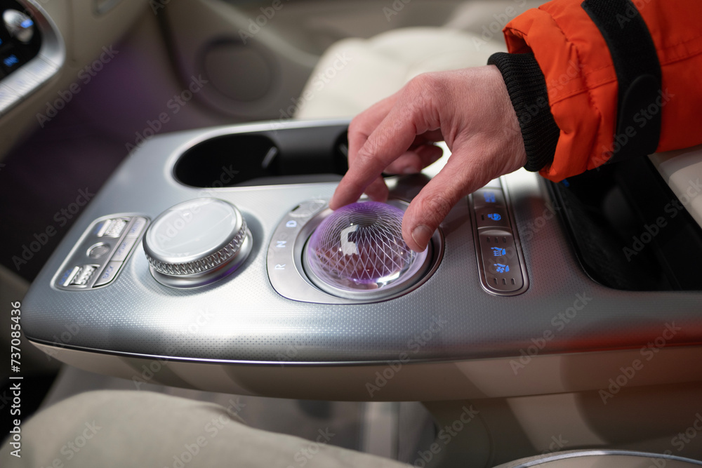 man in car driving Genesis GV60 Electric Car, male hand on button ...