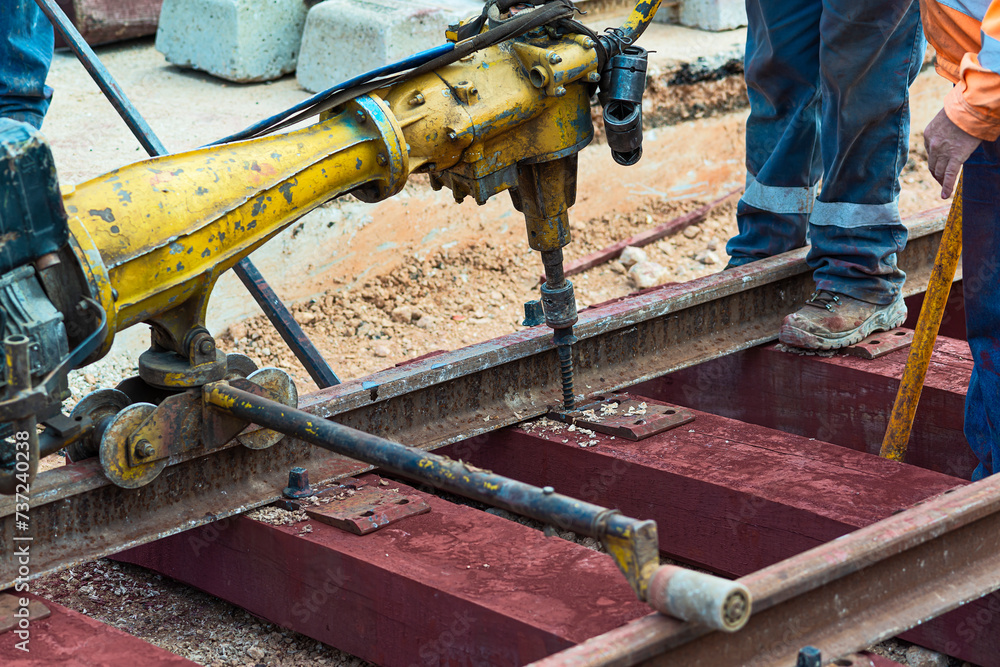 Foto de construction of railway track with wooden sleepers. Worker with ...