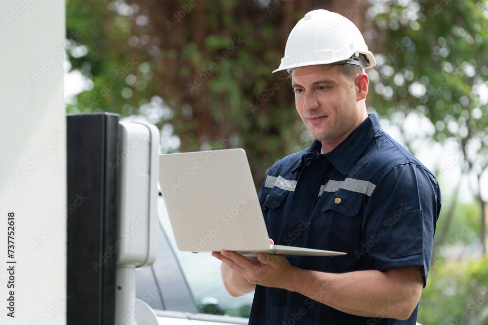Qualified technician working on home EV charging station installation ...