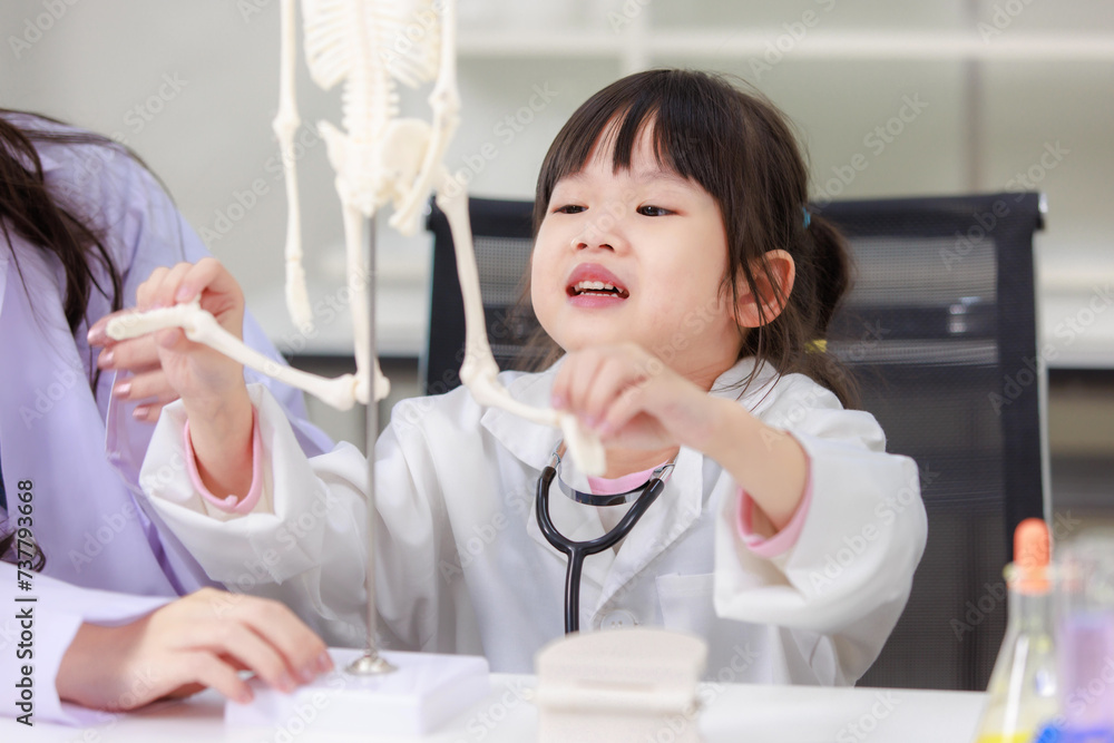 Asian woman doctor physiotherapist explains human fake skeleton hand ...