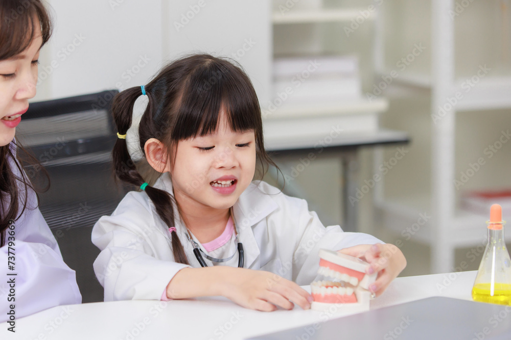 Asian woman doctor physiotherapist explains human fake skeleton teeth ...