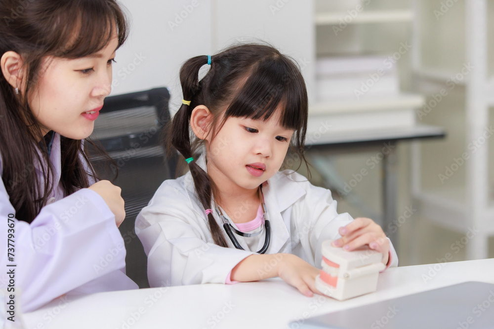 Asian woman doctor physiotherapist explains human fake skeleton teeth ...