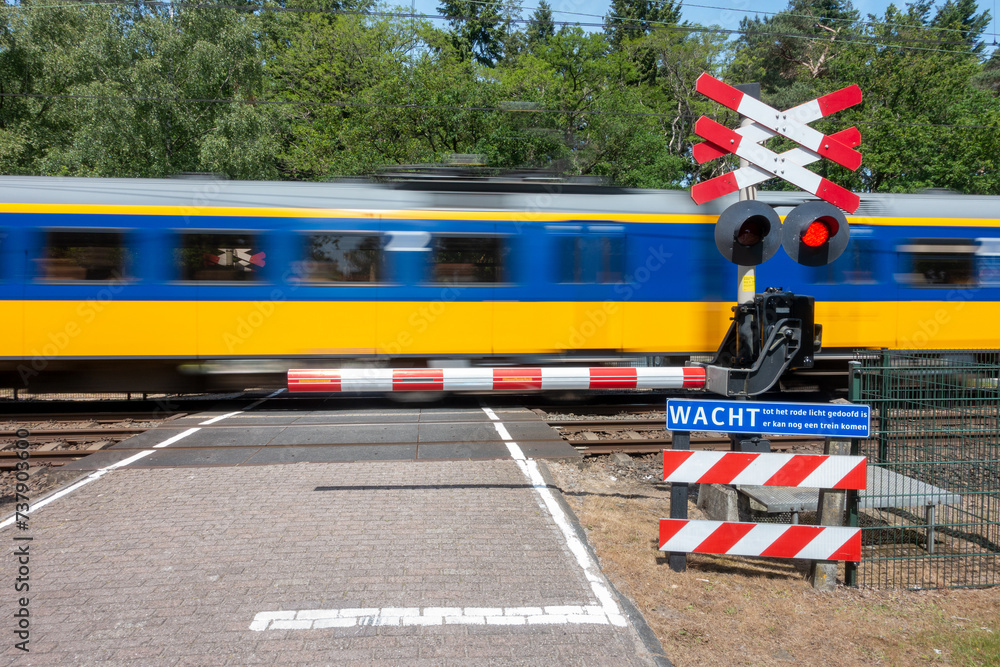 Treinstel van de Nederlandse Spoorwegen passeert een bewaakte ...