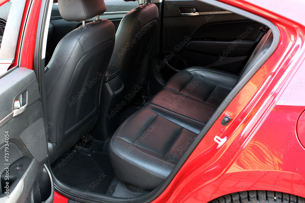 Back passenger seats in modern luxury car. Black leather rear seats ...
