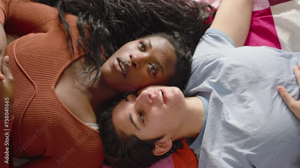 In the bedroom, portrait of a couple of multi-ethnic girls hug and ...