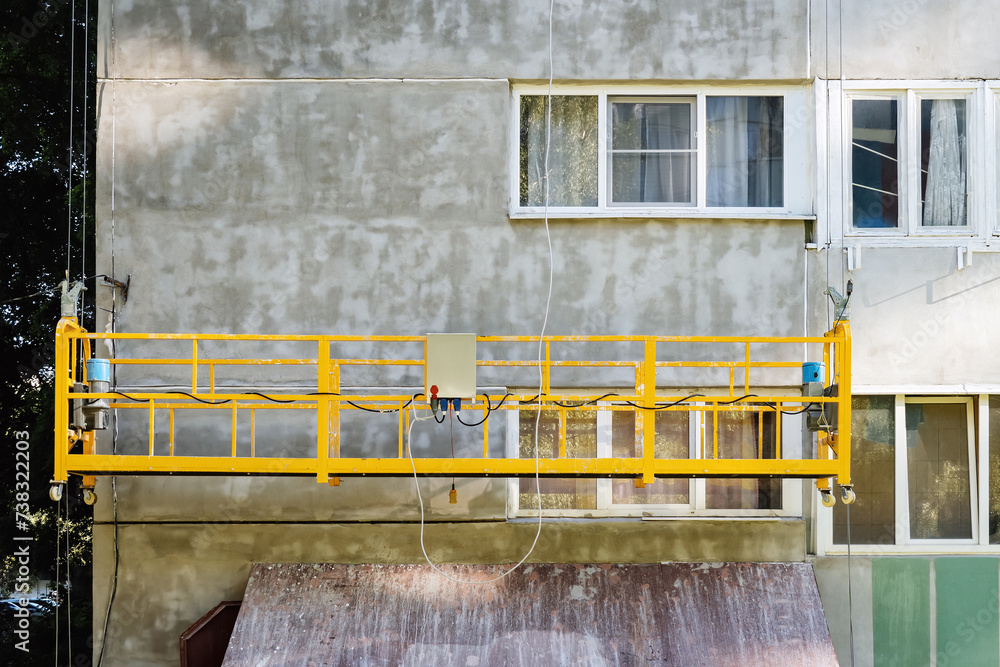 High-altitude works, residential building facade plastering. Suspended ...