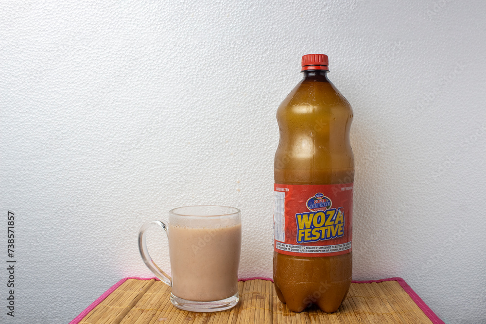 Pouring commercial traditional African sorghum beer Chibuku in a mug ...