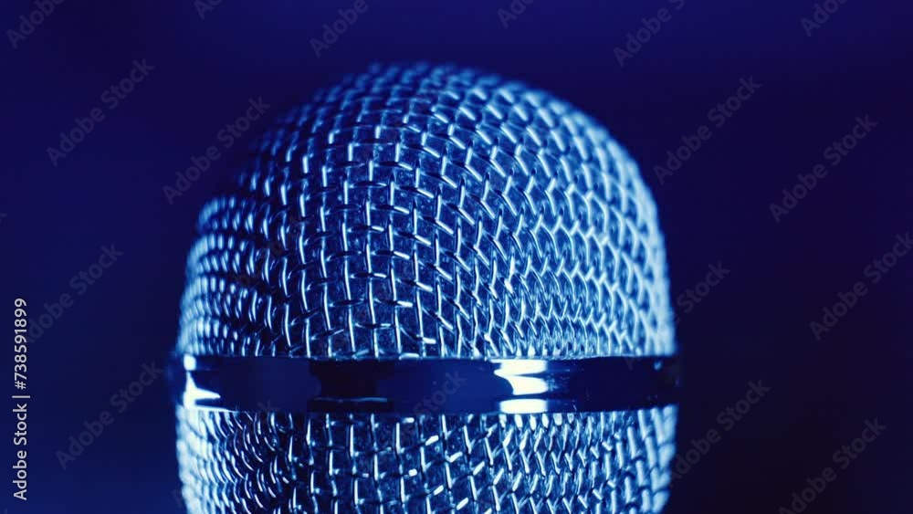 Microphone head rotating with blue light. Concert microphone at dark ...