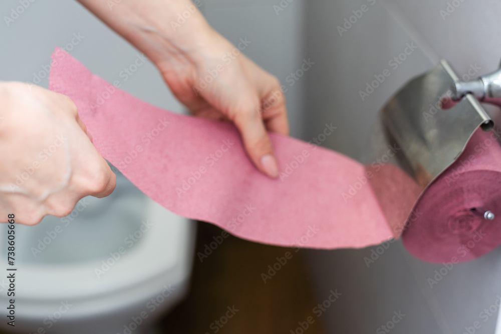 A female hand, woman holding a roll of pink toilet paper, digestive ...